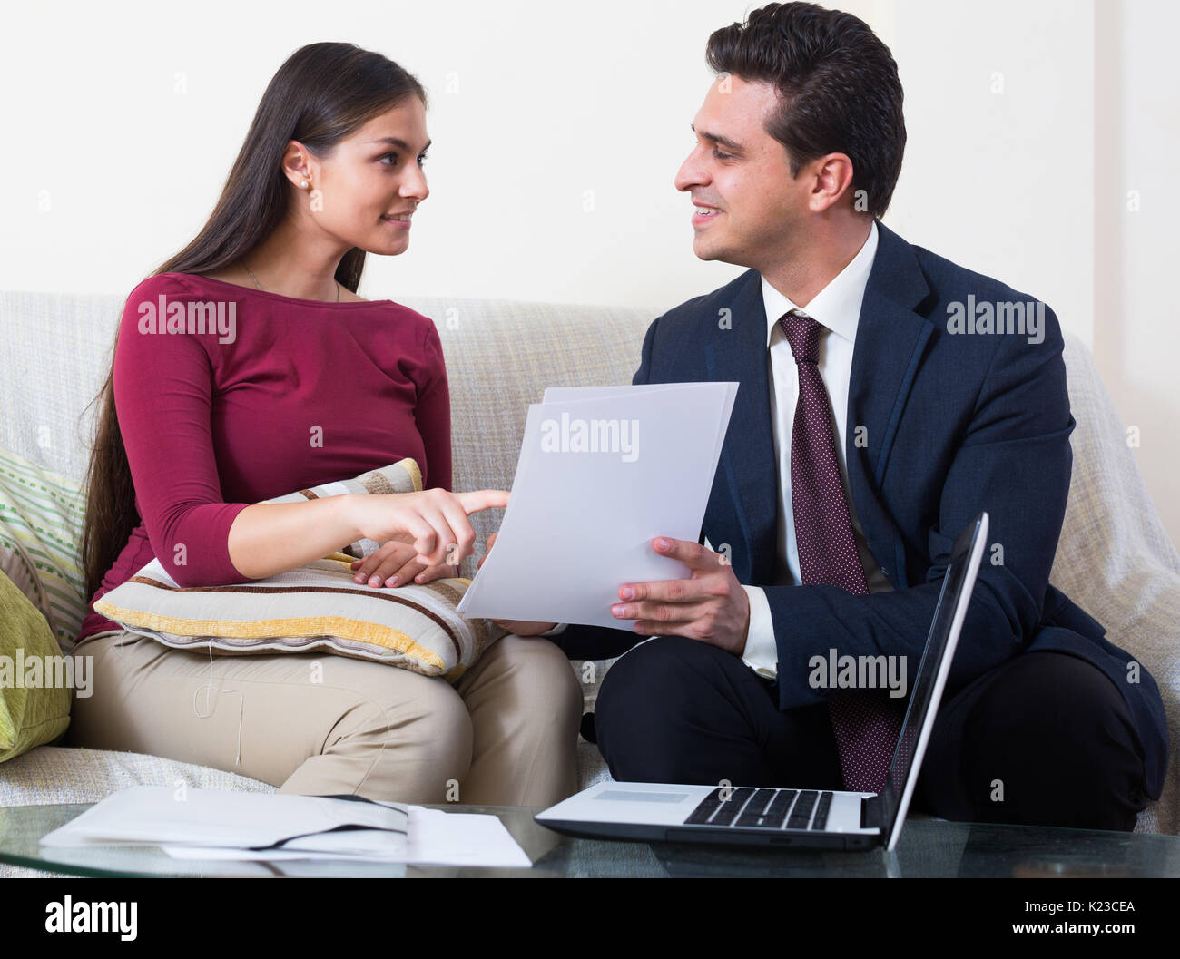 Banking agent showing contract to female client in domestic interior ...