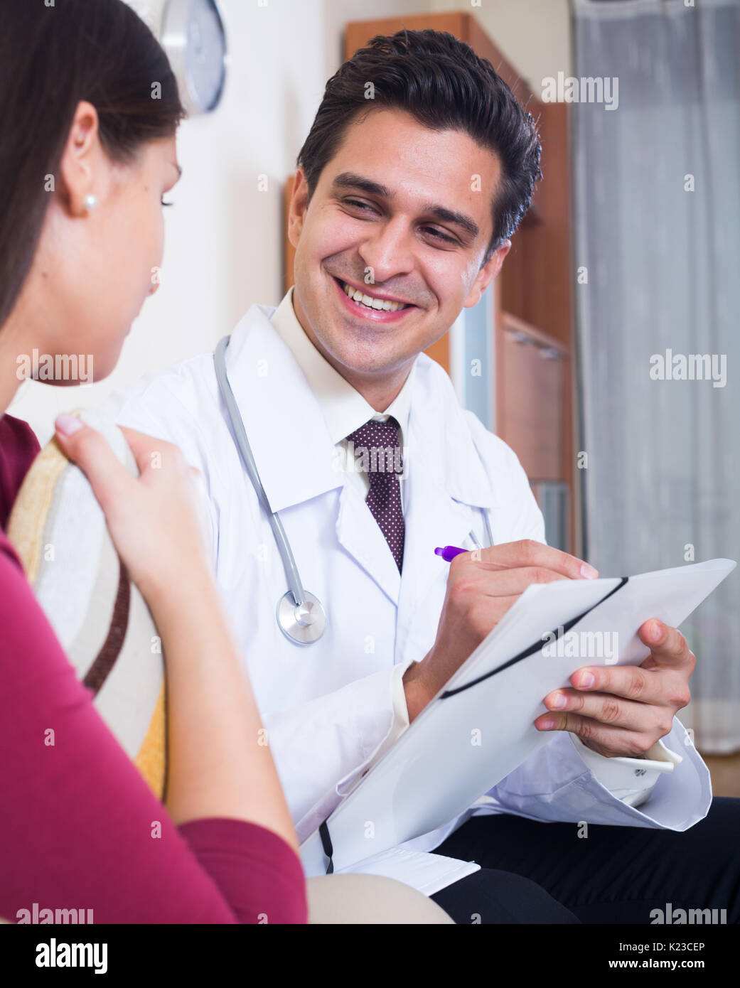 Professional doctor paying female patient a visit for checkup Stock ...