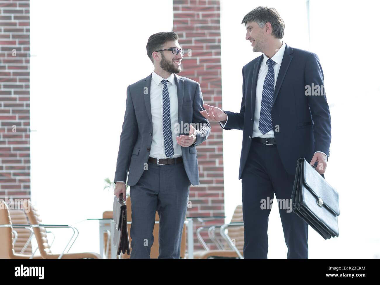 business partners walking down in office building and talking Stock ...