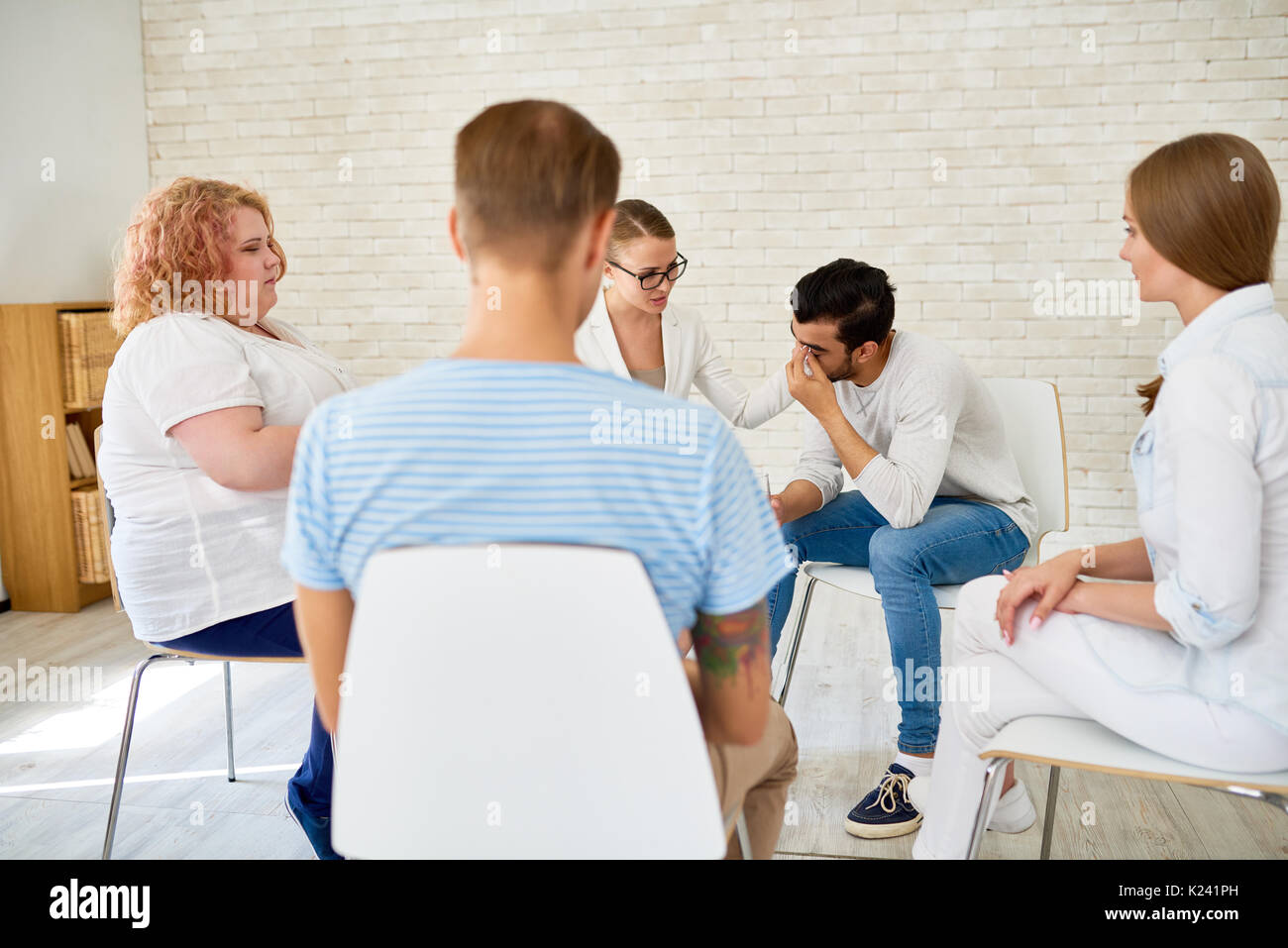 Young Man Sharing Problems in Group Therapy Session Stock Photo - Alamy