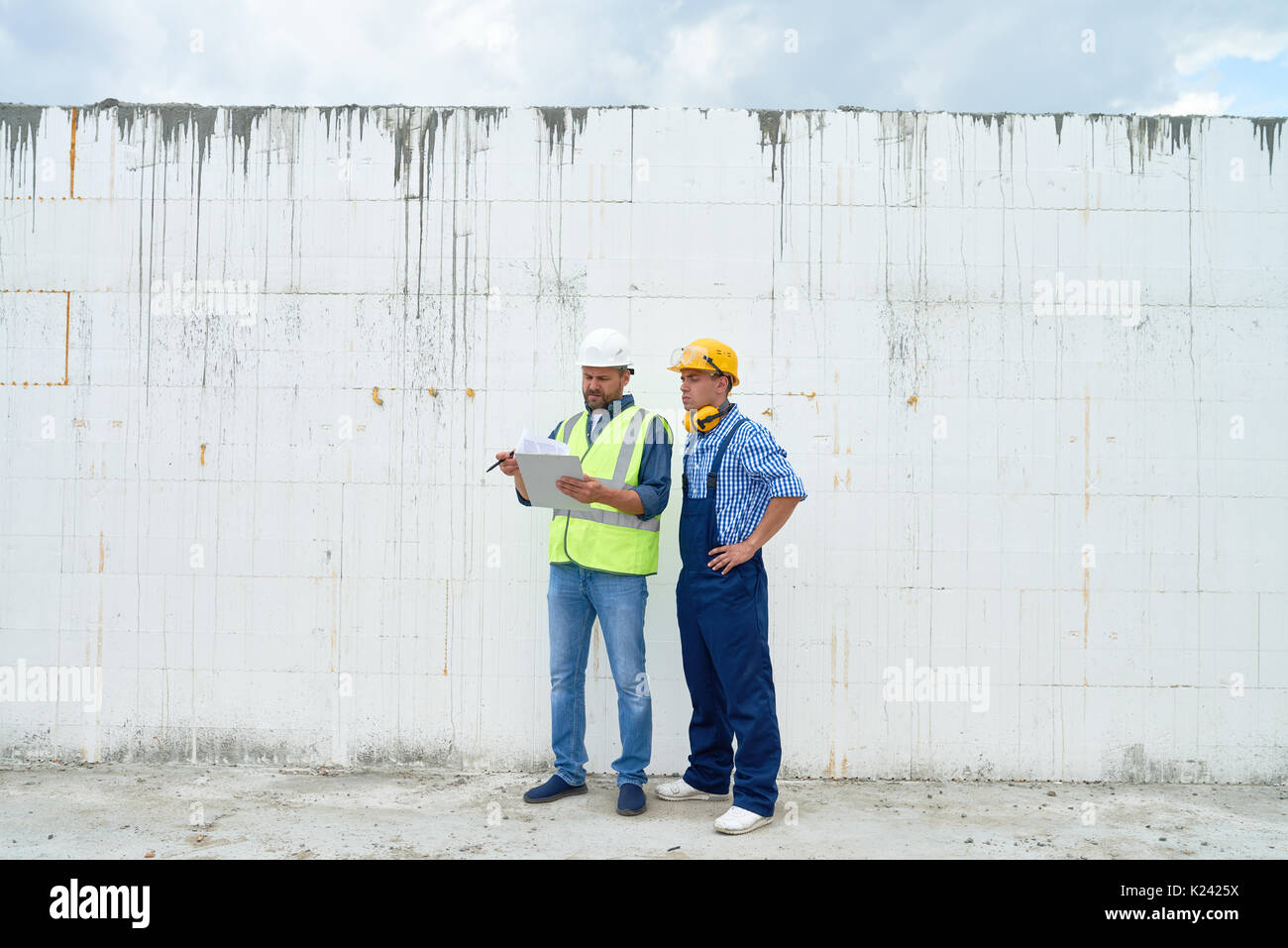 Construction Workers Discussing Building Stock Photo - Alamy
