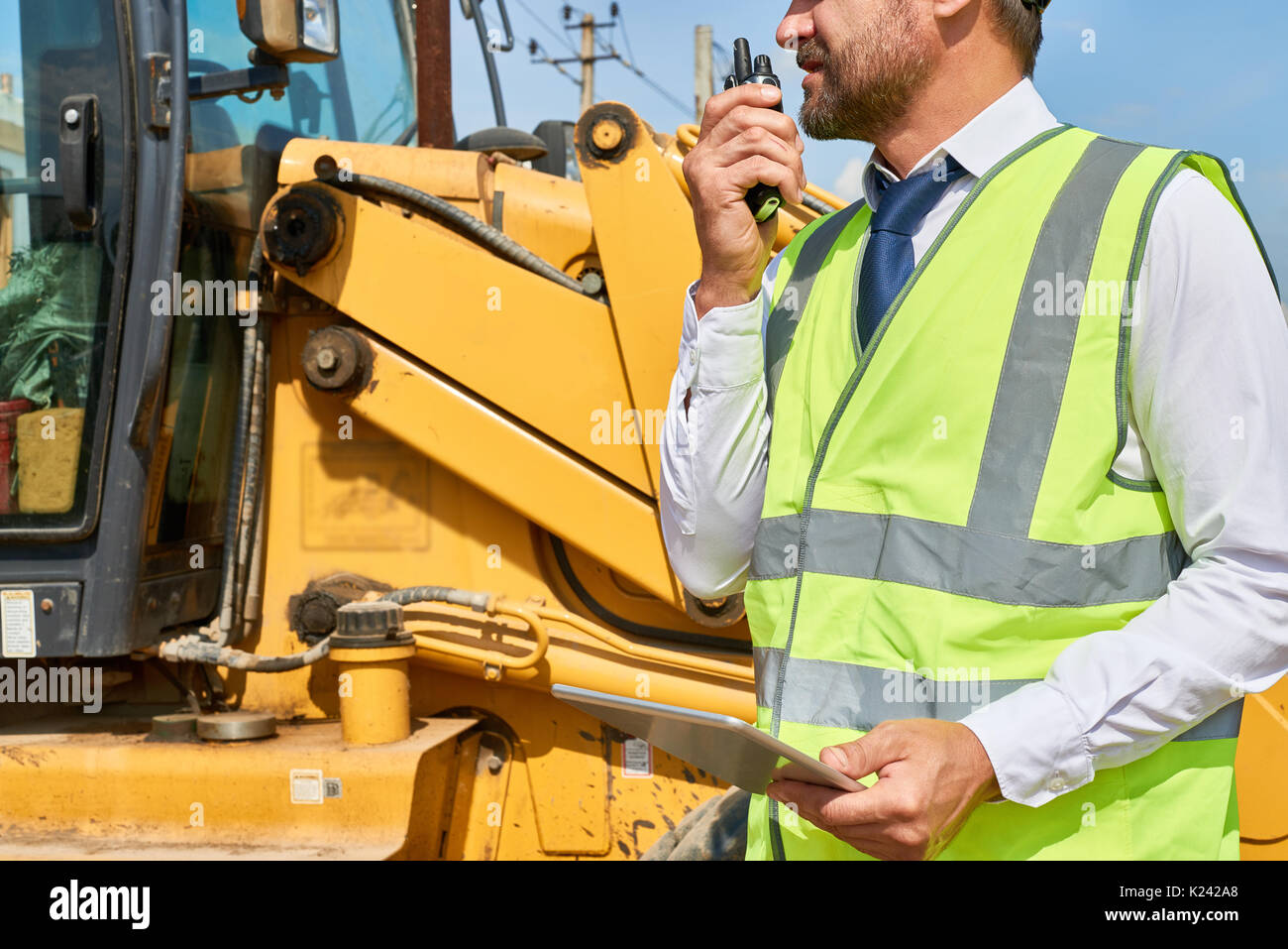 Construction Foreman Giving Instructions by Radio Stock Photo - Alamy