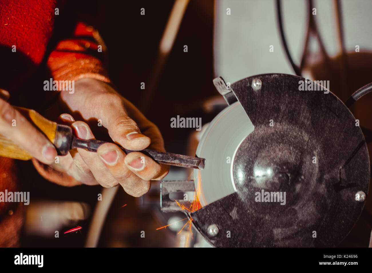 Sharpening a chisel on grinding machine with sparks fly Stock Photo - Alamy