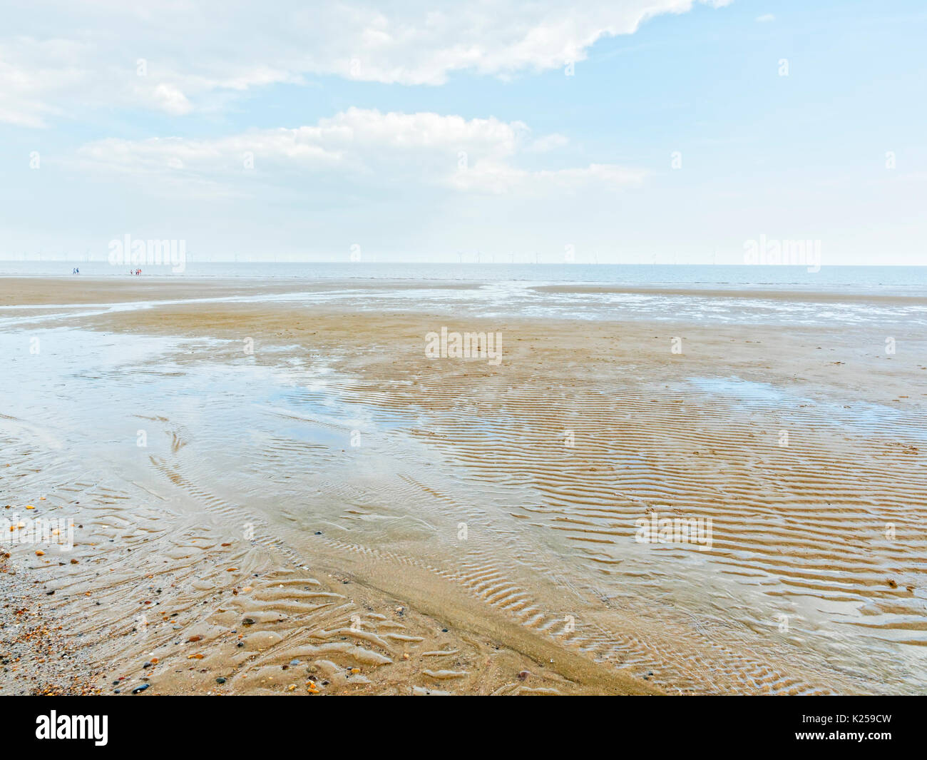 At low tide on Skegness beach rivulets of seawater run towards the sea ...