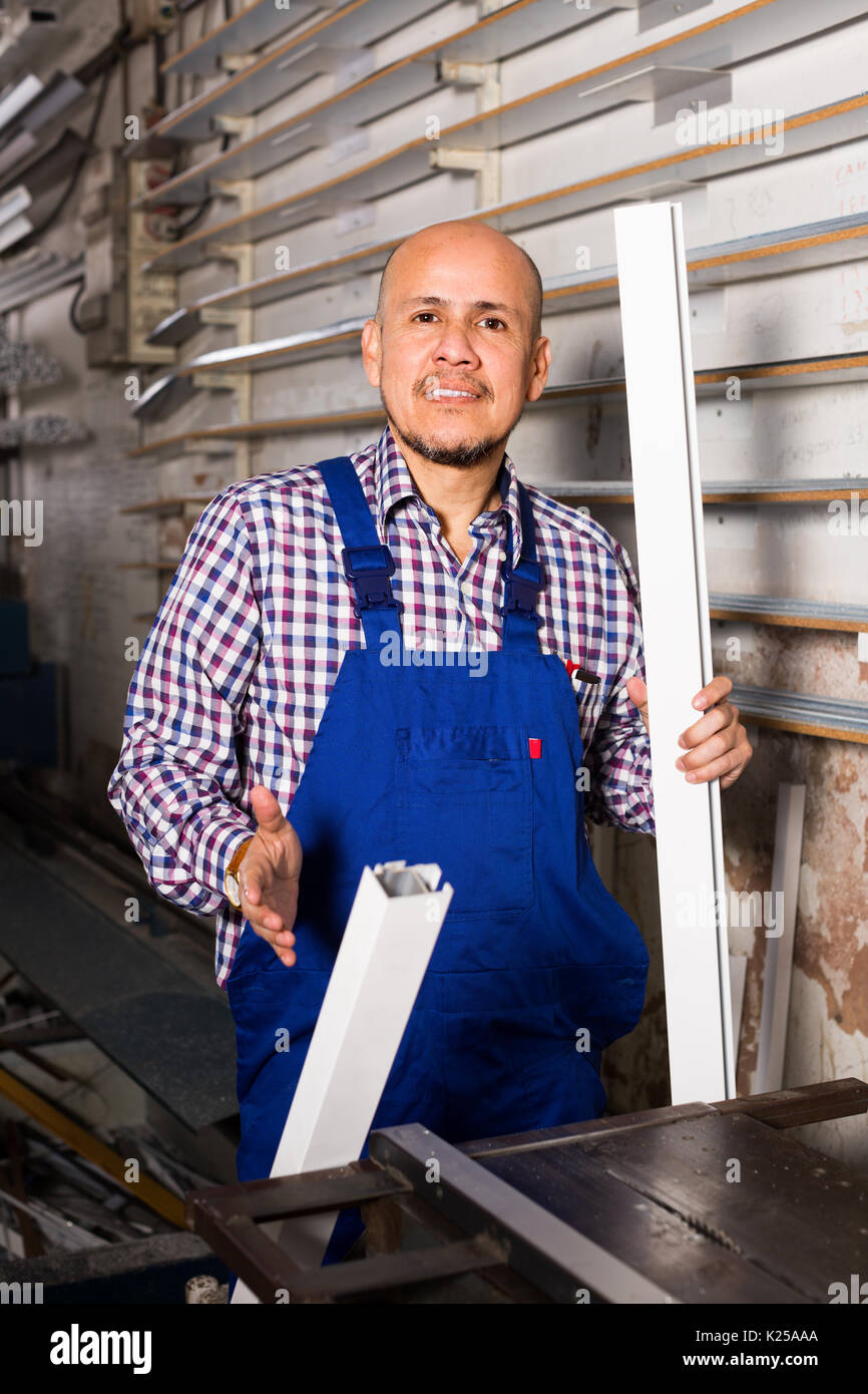 Professional workman 55s working at PVC frames at modern factory Stock ...