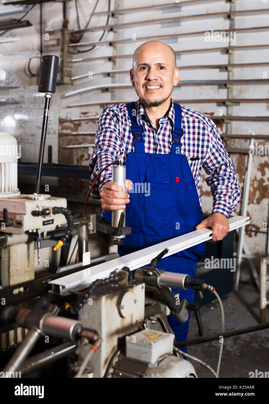 Smiling labour working on lathe machine at factory Stock Photo - Alamy
