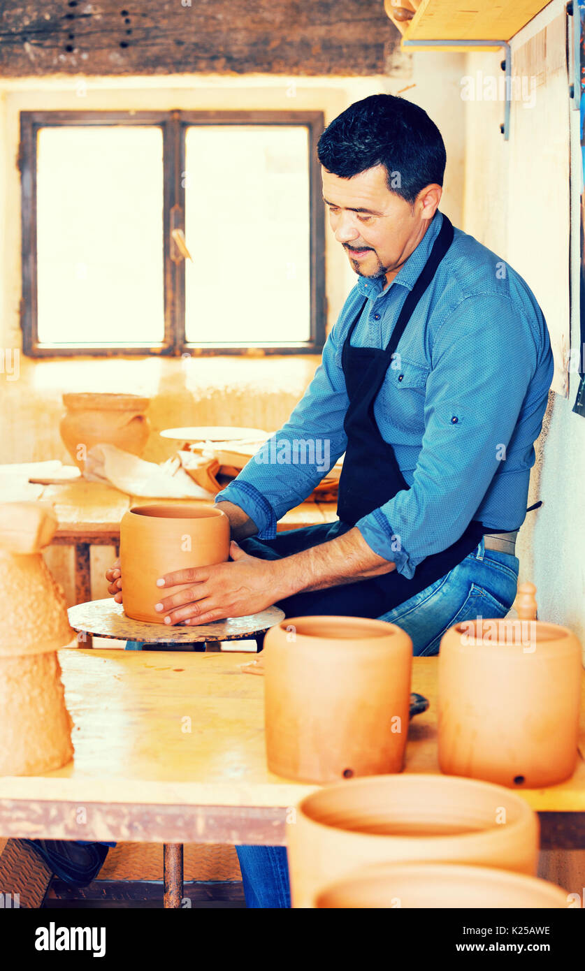 Serious mature man making pot using pottery wheel in studio Stock Photo ...