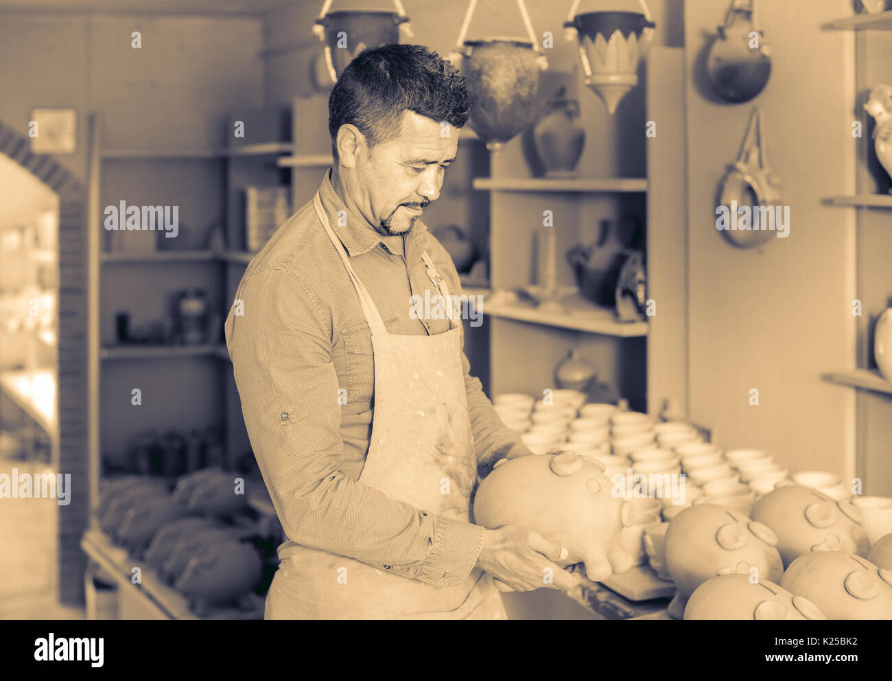 Smiling russian man potter holding ceramic vessels in atelier Stock ...