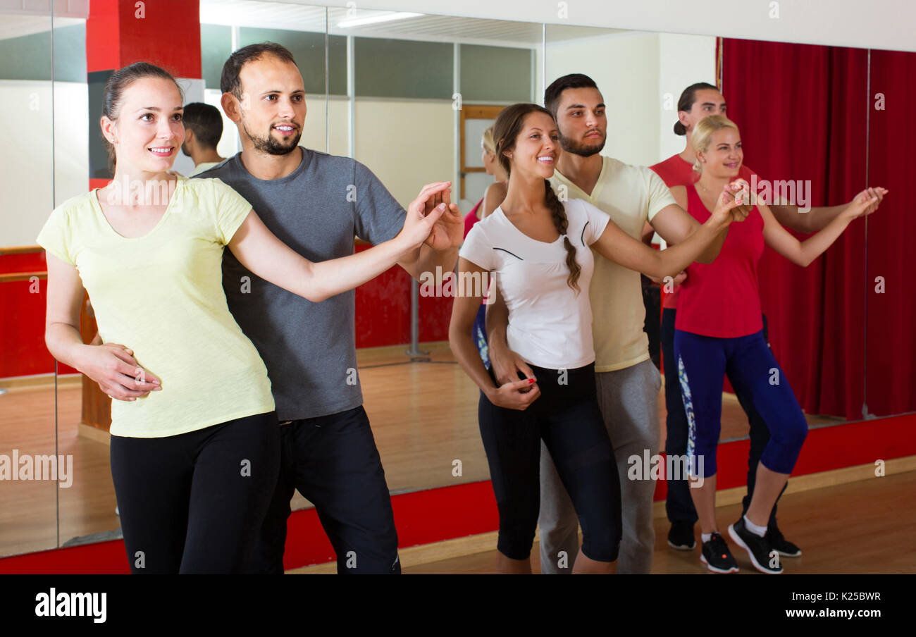 Group of smiling people dancing salsa in studio Stock Photo - Alamy