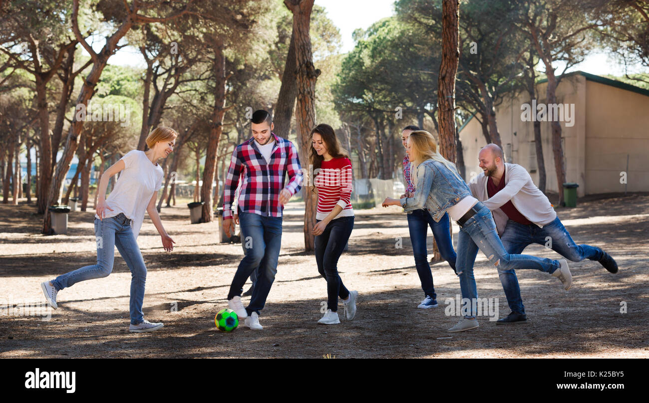 Several friends running with the ball and laughing Stock Photo - Alamy