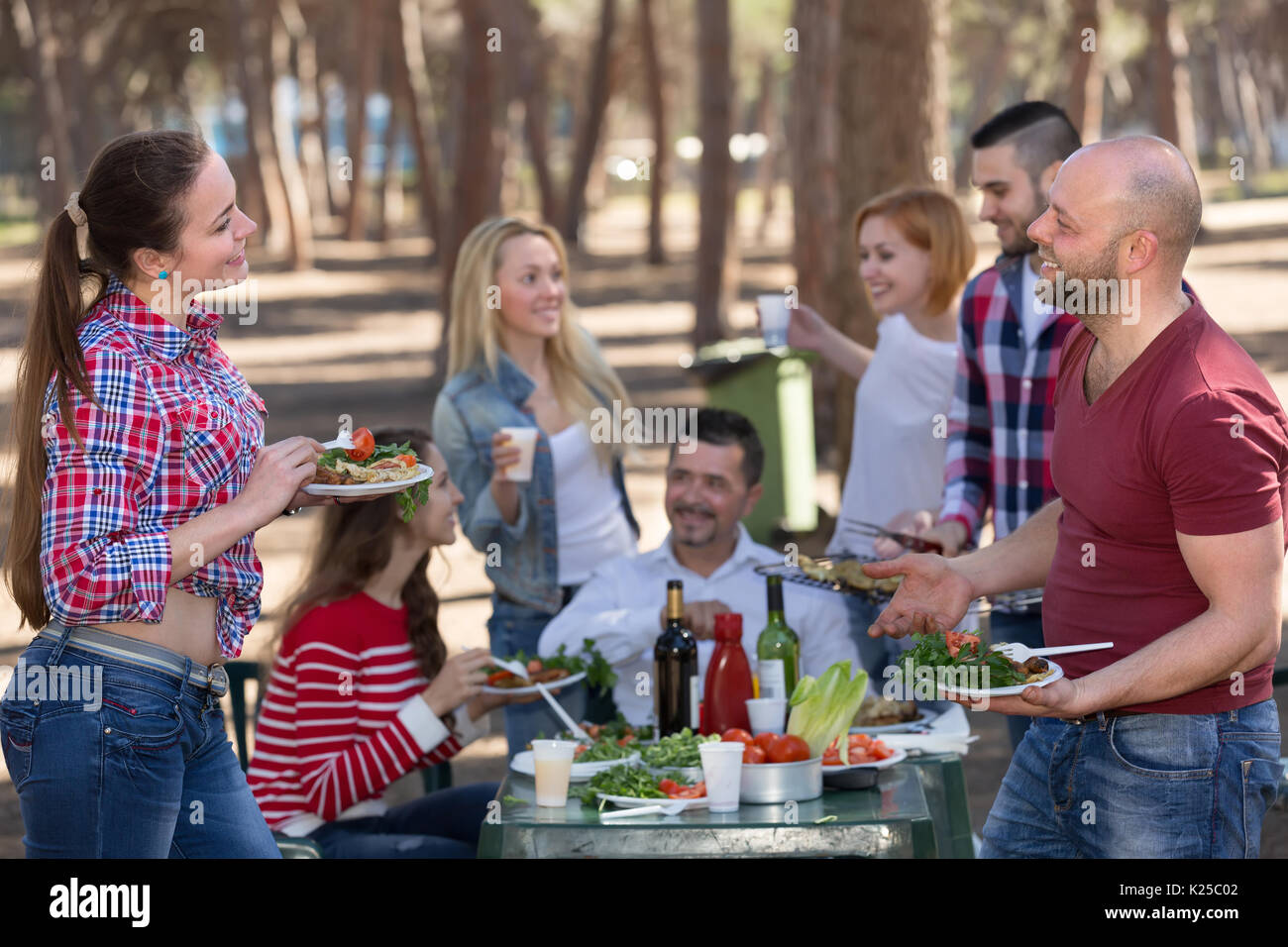 Smiling colleagues making grill at summer corporate party. Selective ...