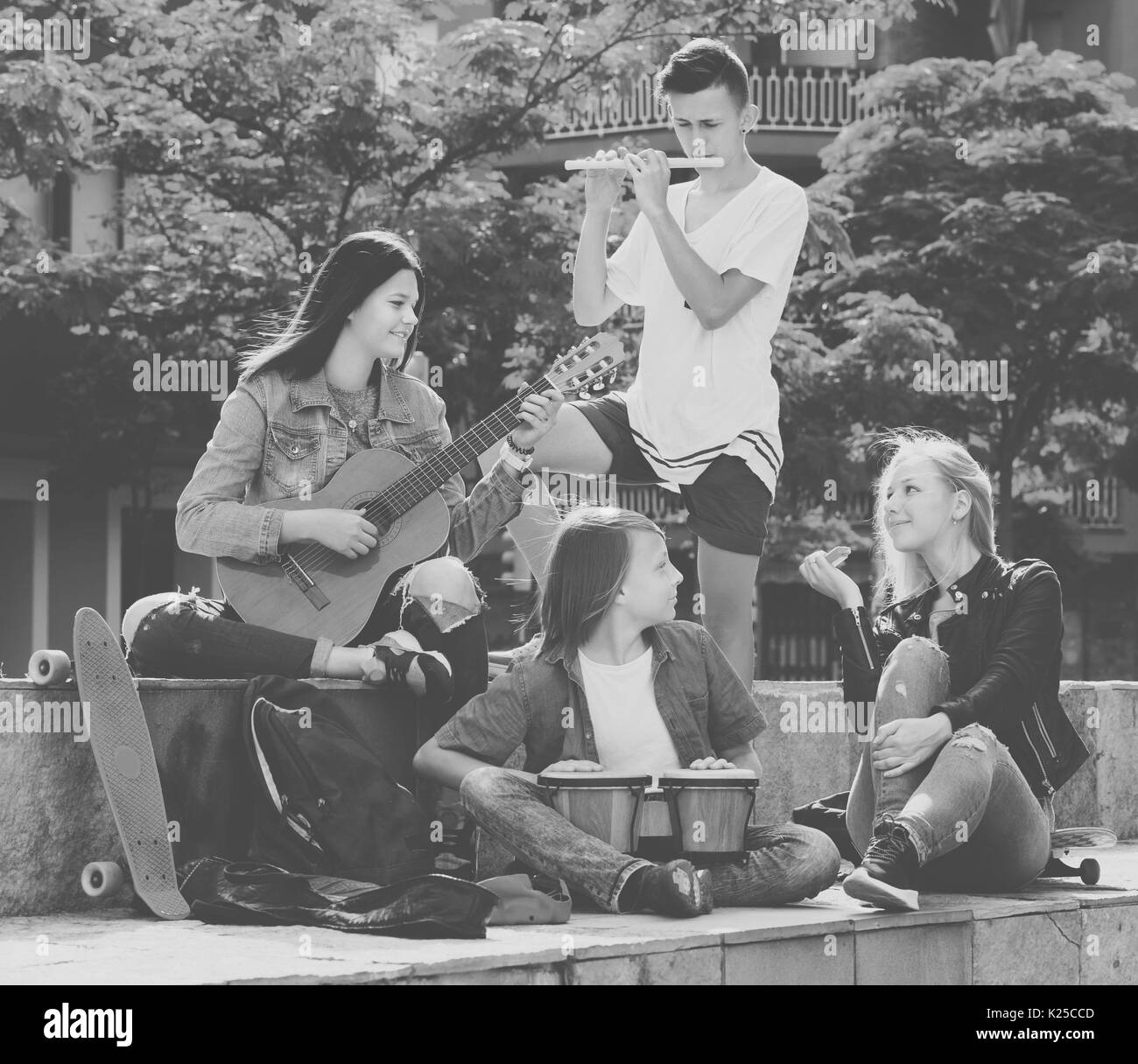 Young teenagers friends with musical instruments together outdoors ...