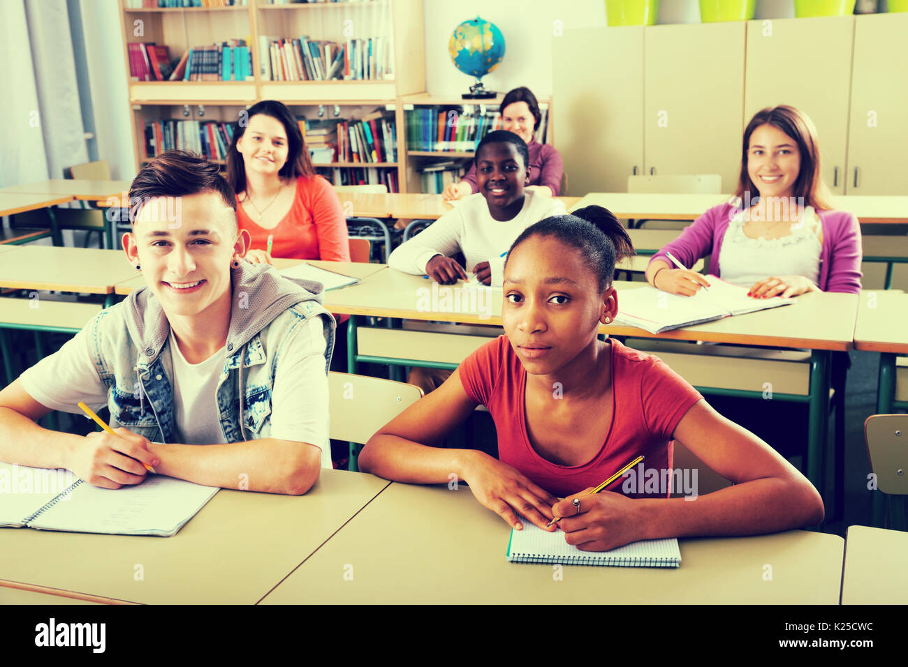 Portrait of happy multiethnic school pupils taking a lesson in the ...
