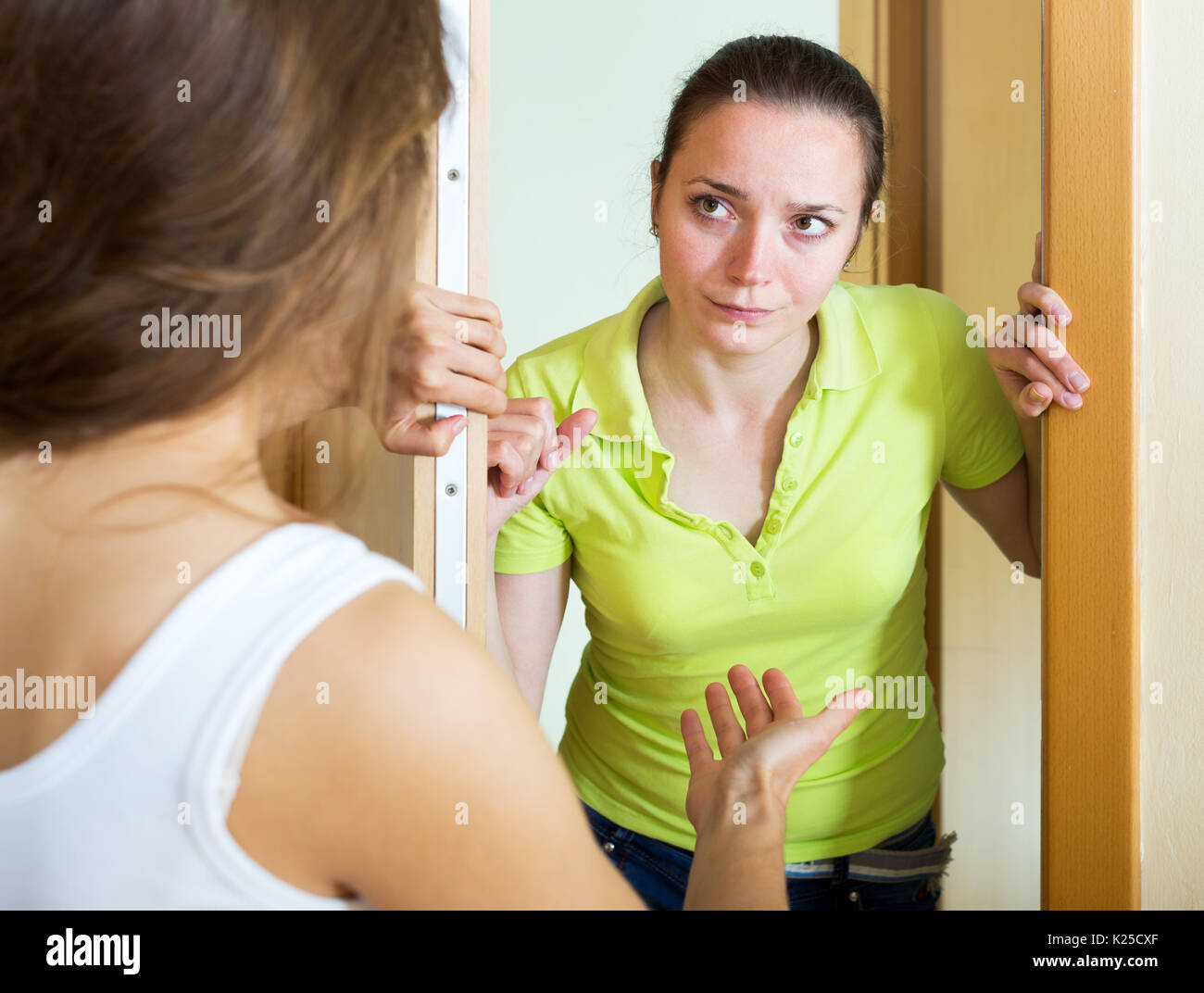 Sad young girl visiting neighbour at the door Stock Photo - Alamy
