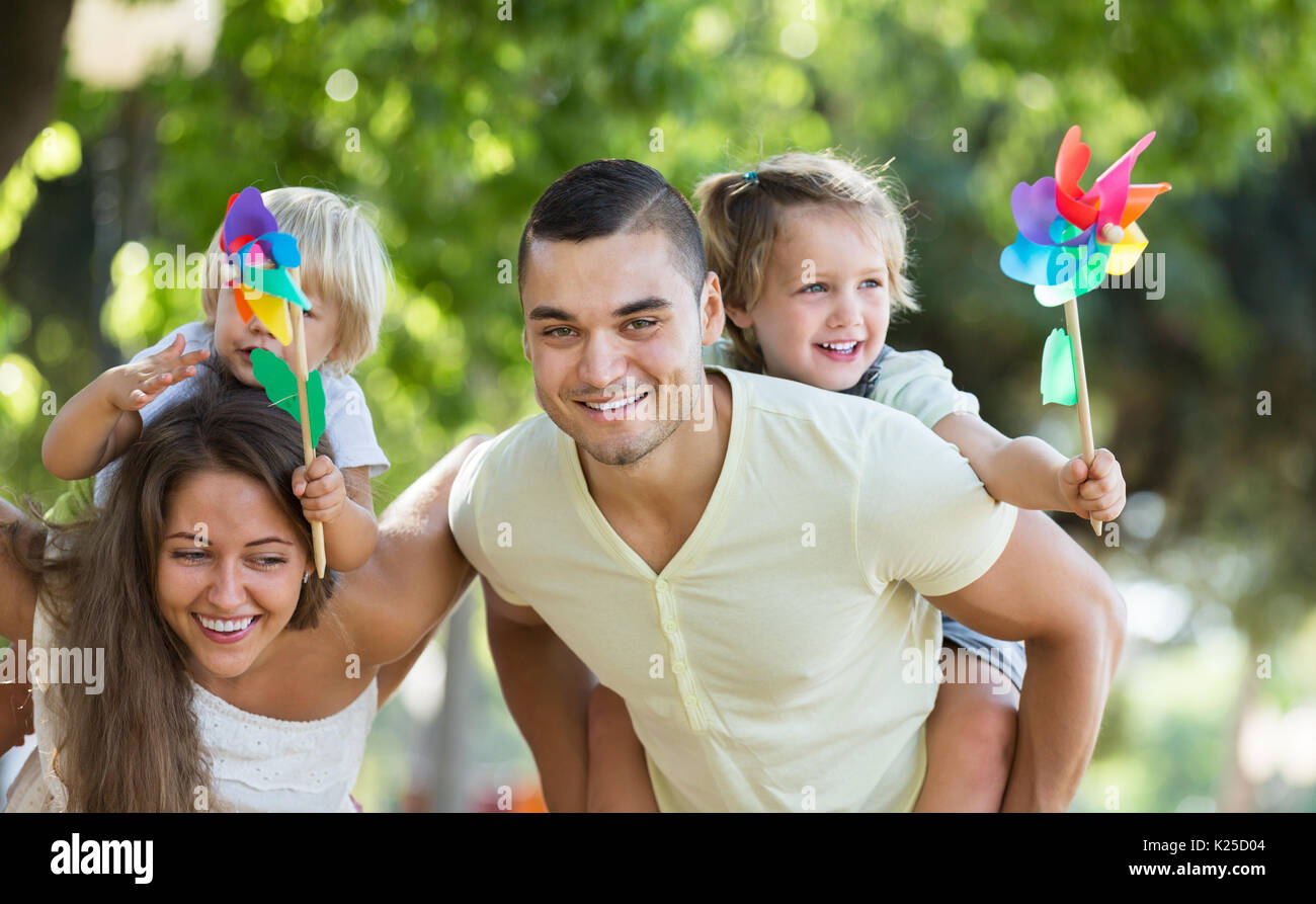 Young parents walking with children on vacation day at park Stock Photo ...