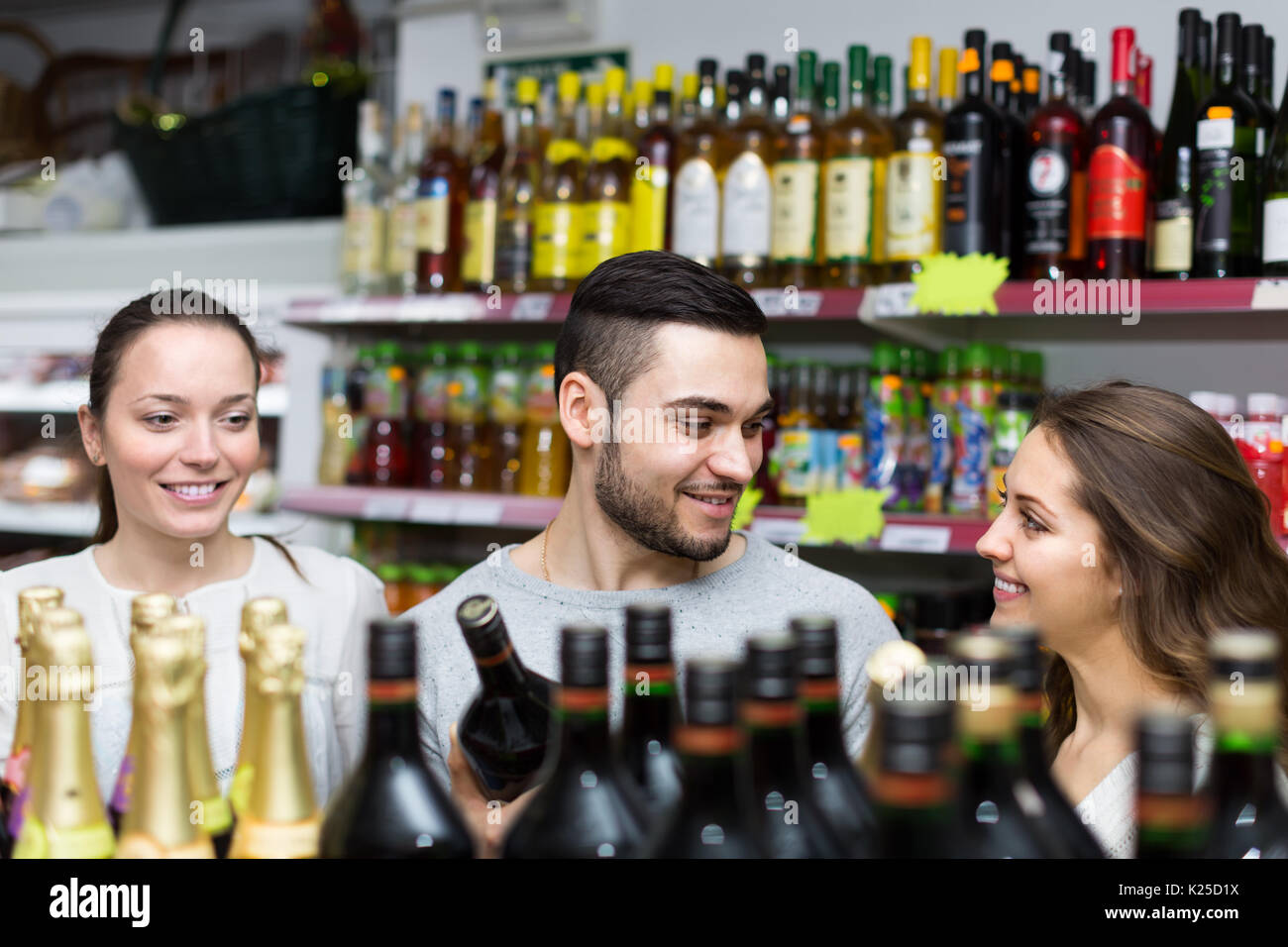Positive people buying drinks for dinner at food shop Stock Photo - Alamy