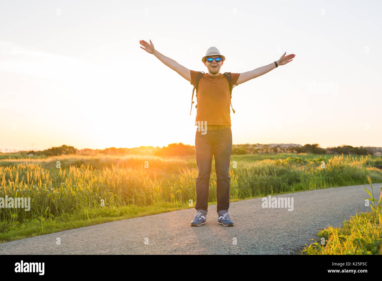 Man with arms raised, looking out over field Stock Photo - Alamy