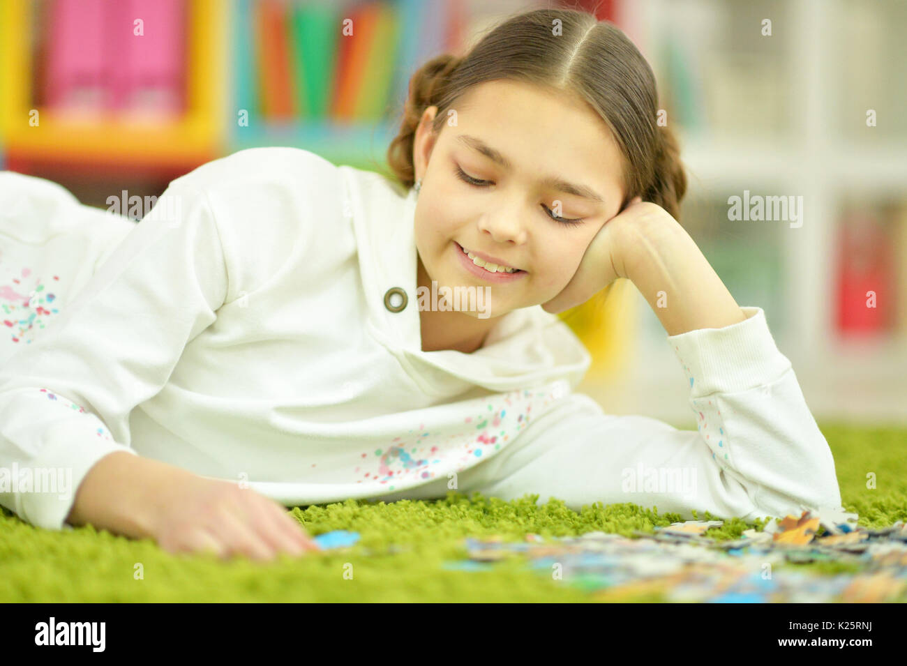 Portrait of a cute little girl collecting puzzles Stock Photo - Alamy
