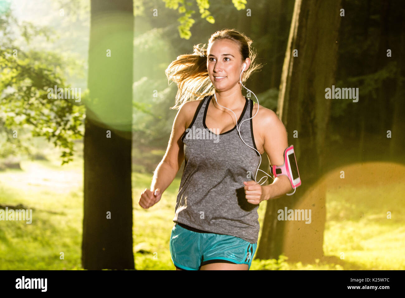 Beautiful fitness woman is running outdoors Stock Photo - Alamy