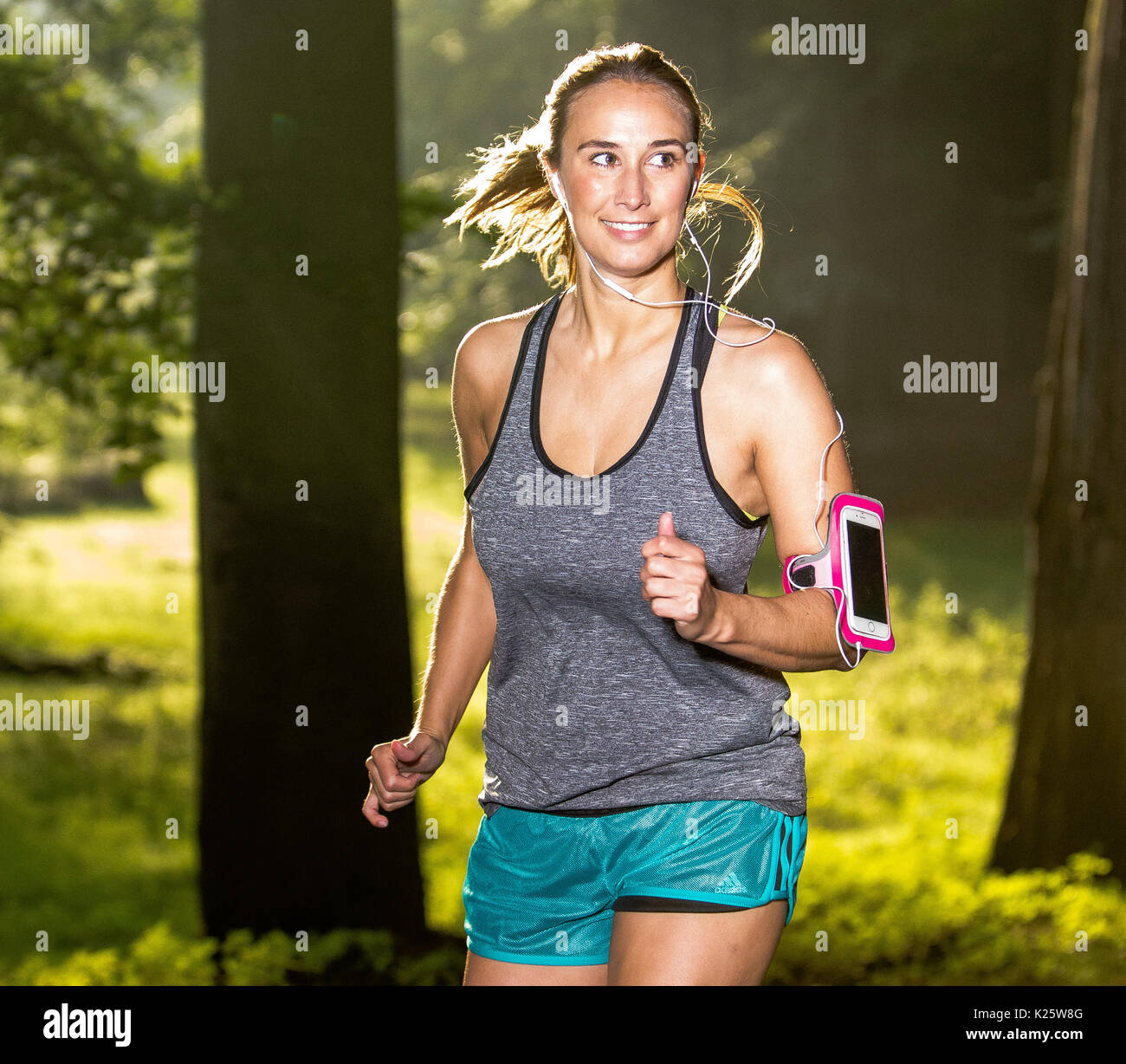 Beautiful fitness woman is running outdoors Stock Photo - Alamy