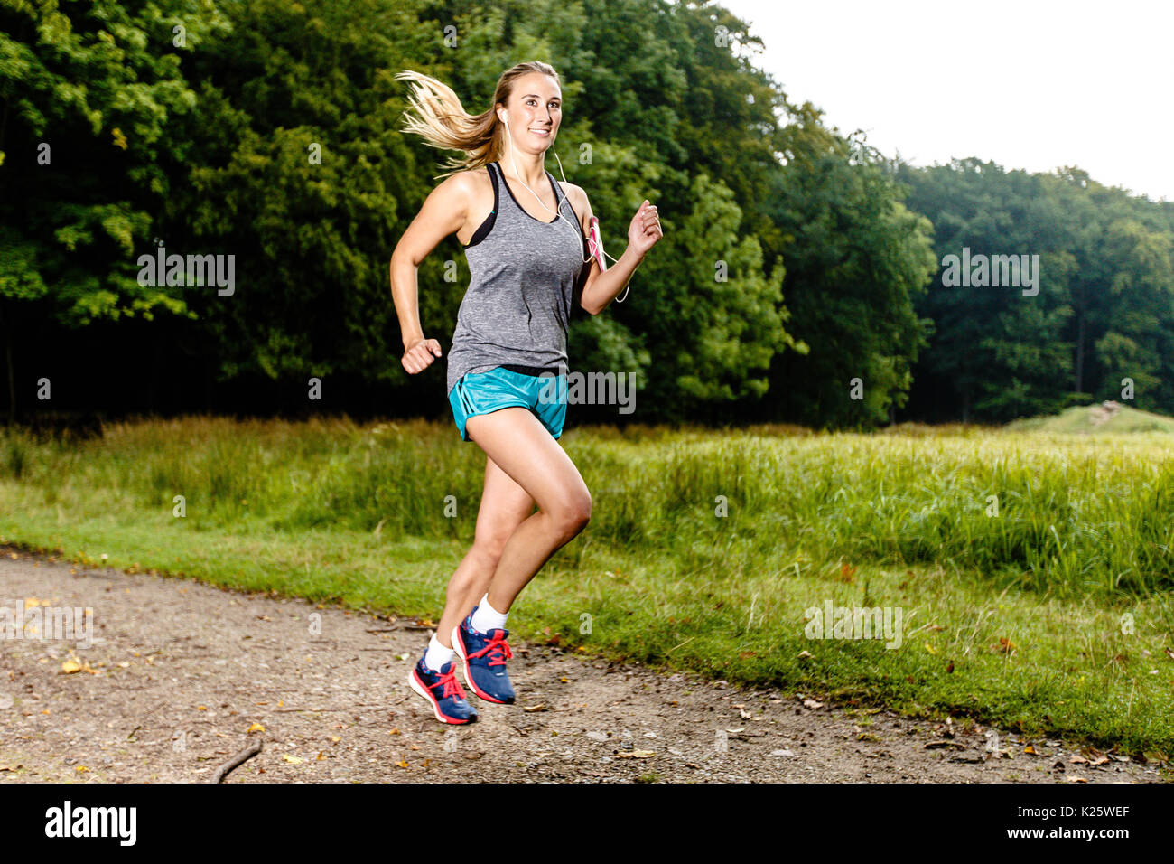 Beautiful fitness woman is running outdoors Stock Photo - Alamy