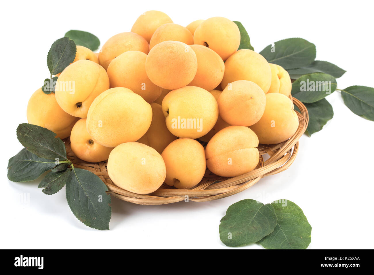 fresh apricots on a white background with leaves and a basket Stock ...