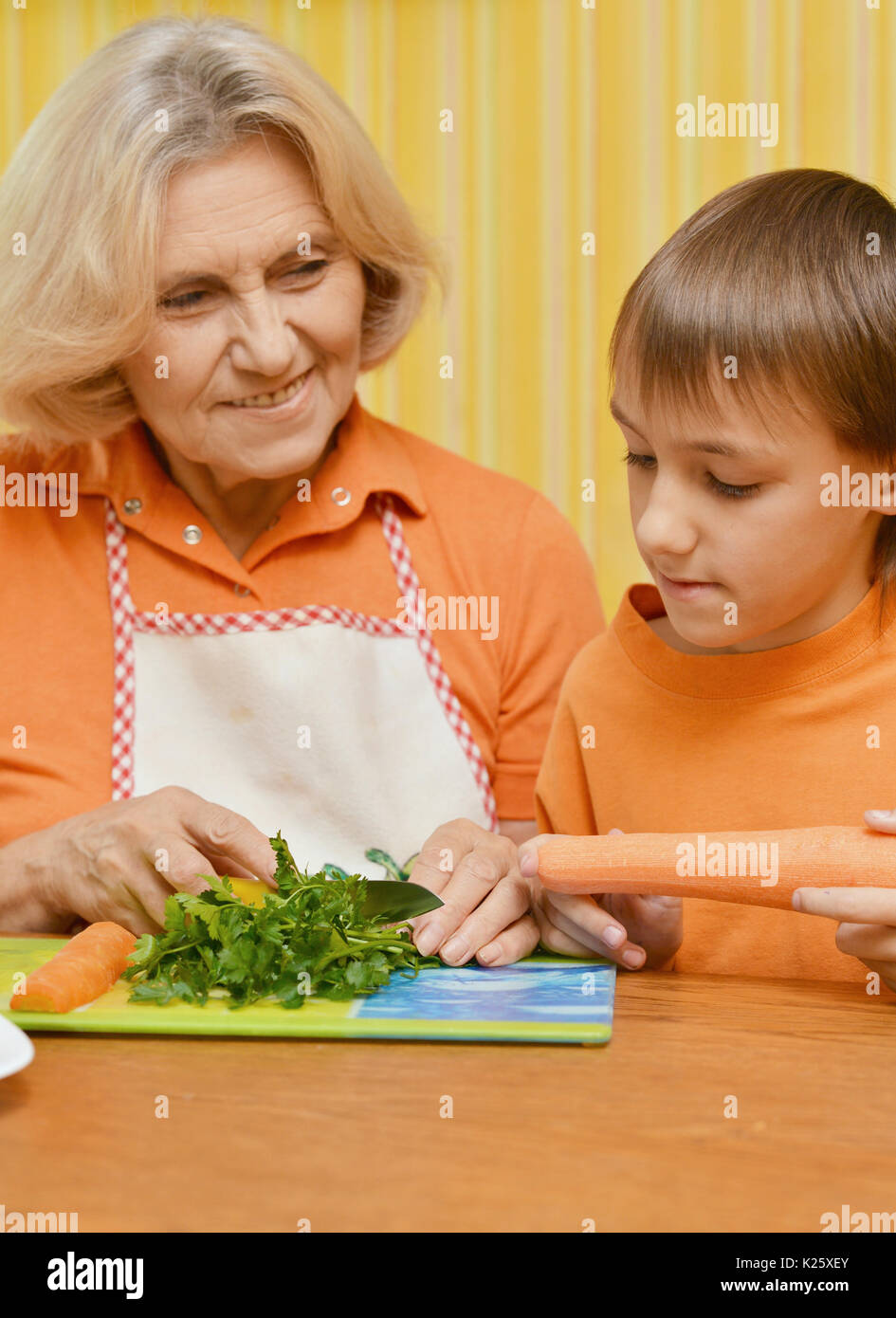 grandmother and grandson cutting vegetables at kitchen Stock Photo - Alamy