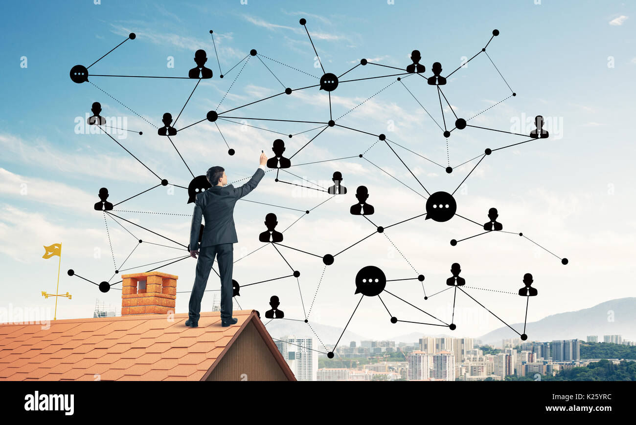 Businessman on house roof presenting networking and connection c Stock ...