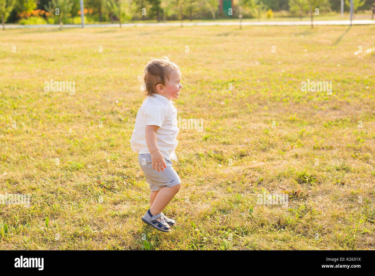 Happy laughing baby boy running on summer or autumn field Stock Photo ...