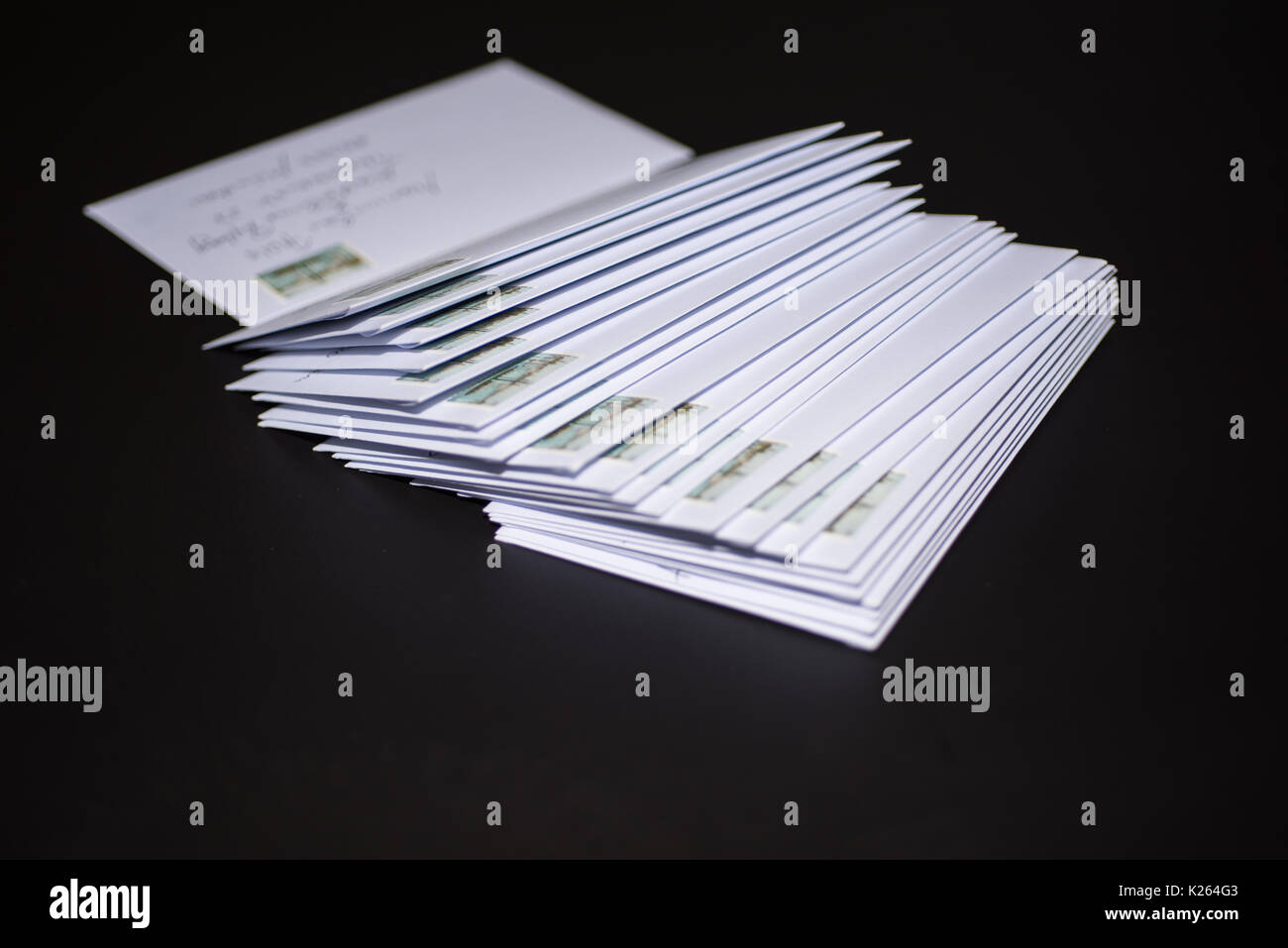 Stack of franked letters in white envelopes on black background Stock ...