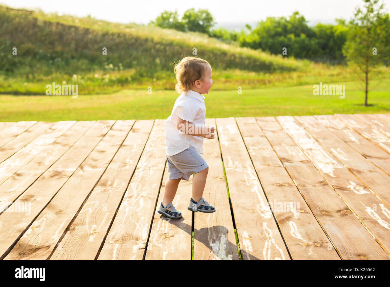 Happy laughing baby boy running on summer or autumn field Stock Photo ...