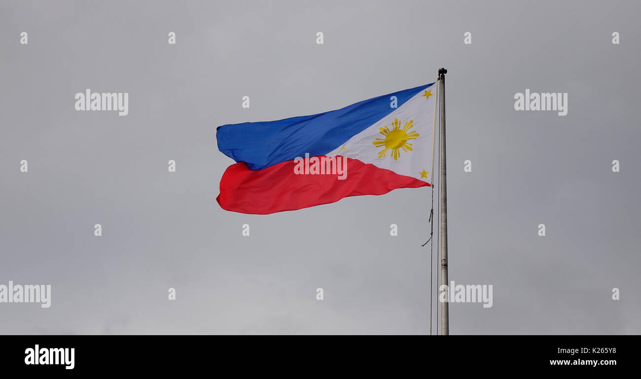 Philippines flag waving in the sky at downtown in Manila, Philippines ...