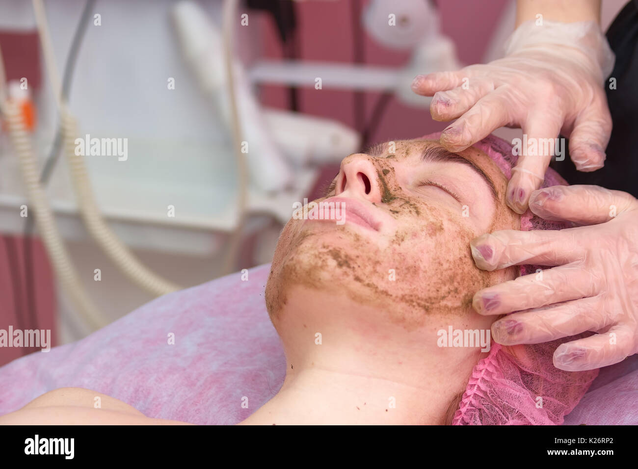 Coral face peeling. Cosmetician is applying facial mask. Organic ...