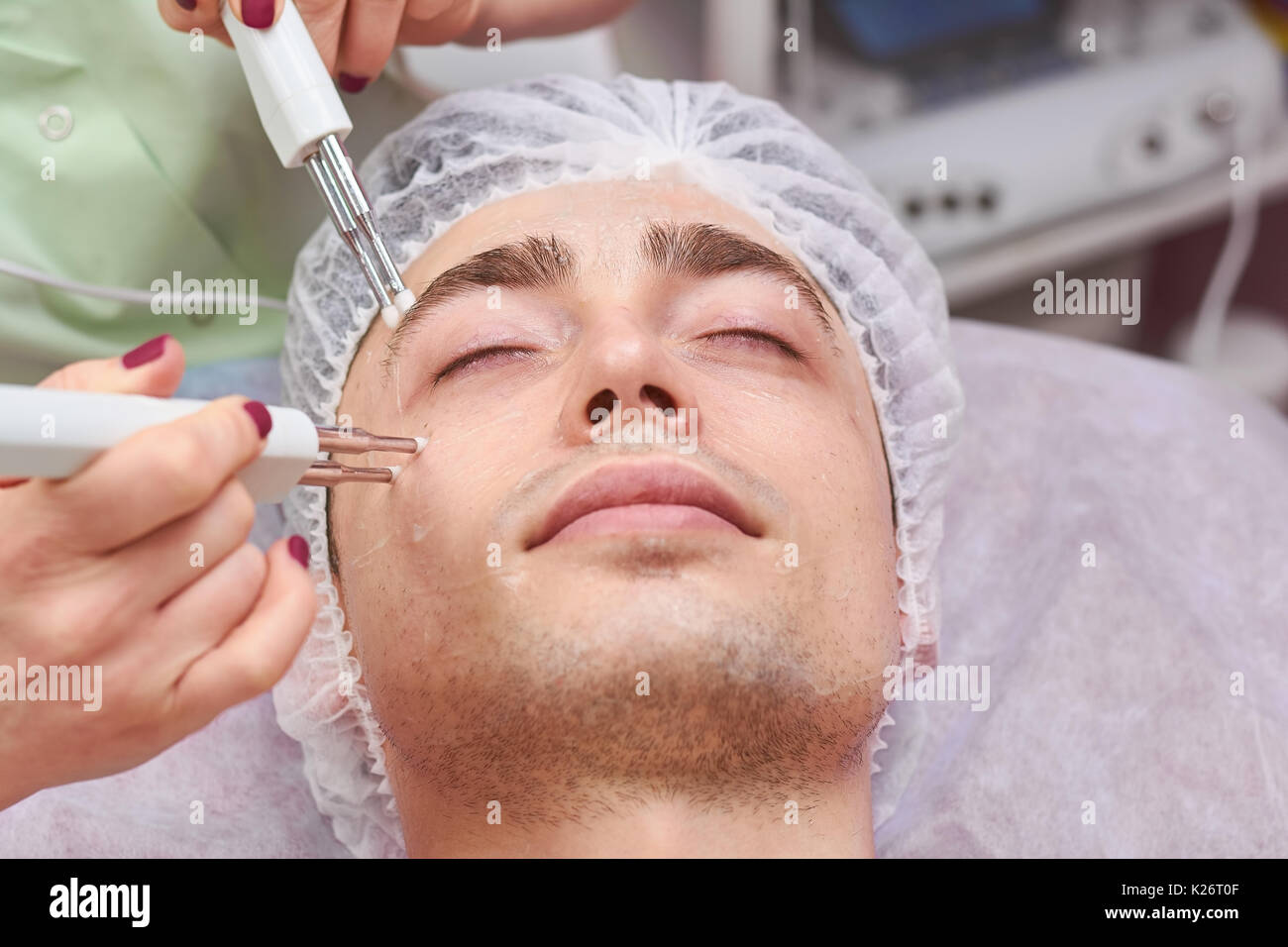 Microcurrent face therapy close up. Young man, cosmetology procedure ...