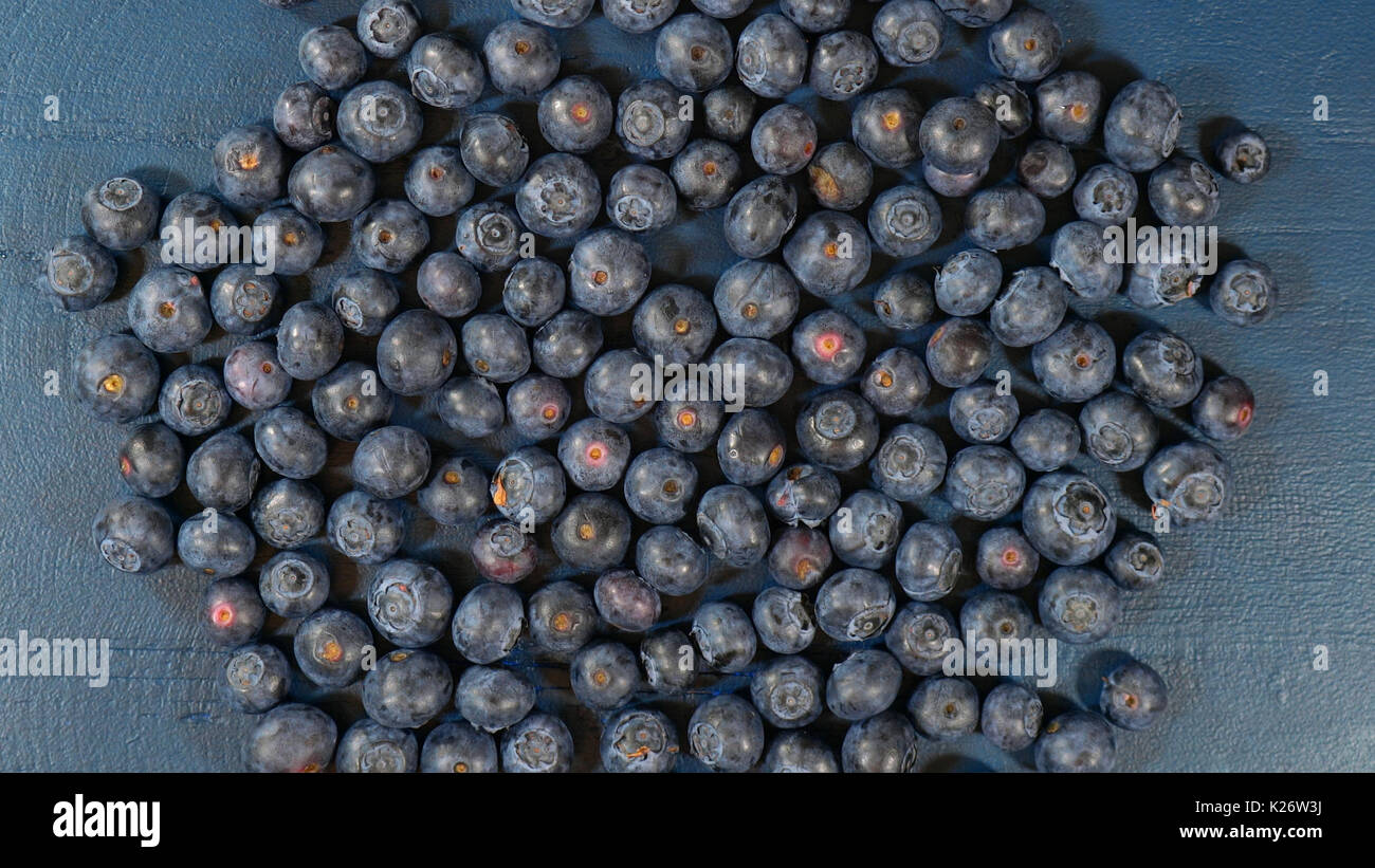 Blueberries on dark blue rustic wood table overhead Stock Photo - Alamy