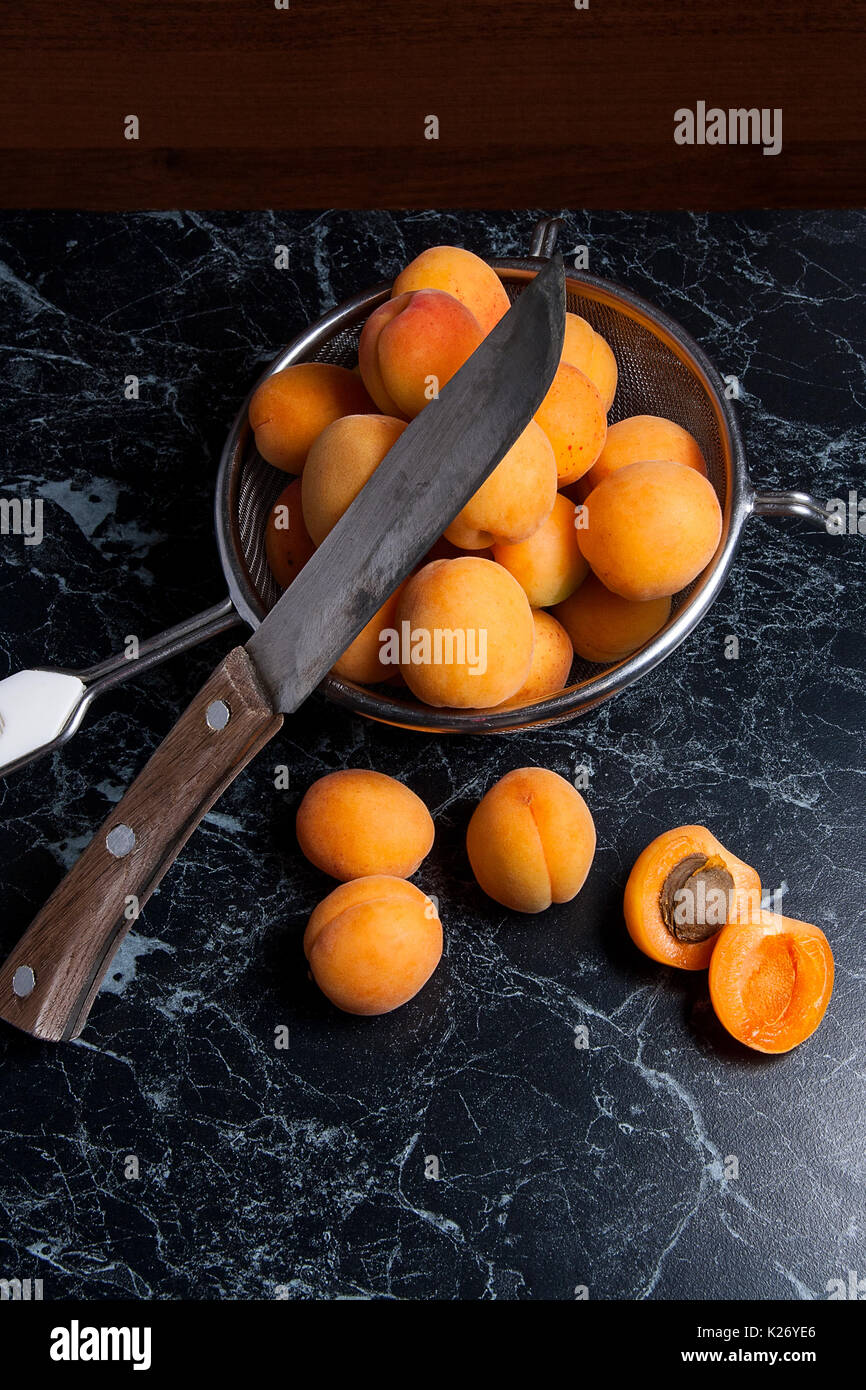 Ripe organic apricots in steel colander vintage knife. Composition in ...