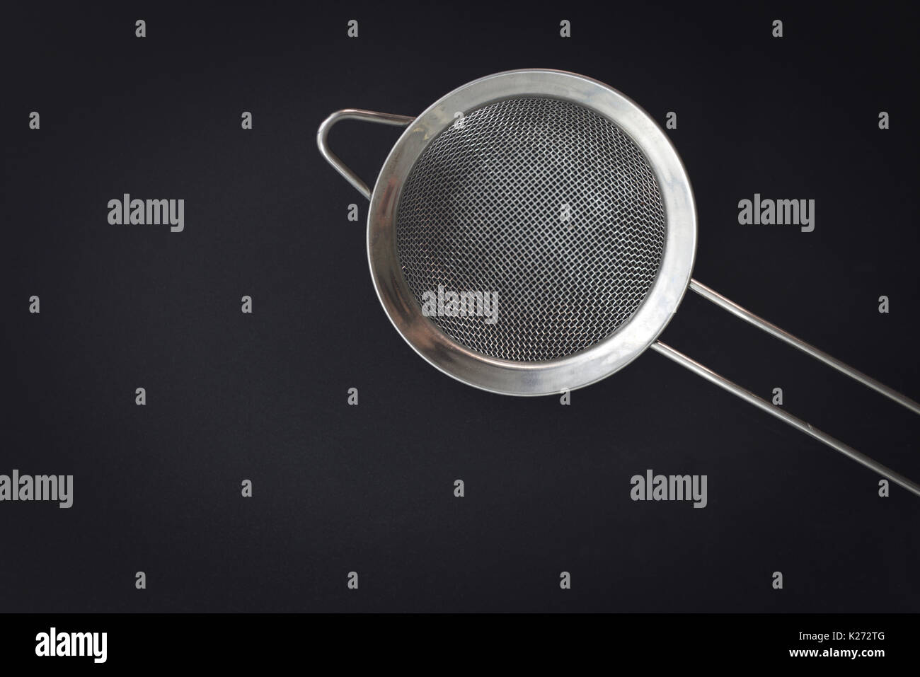 kitchen tools sieve flour or sugar filter top view on black background ...