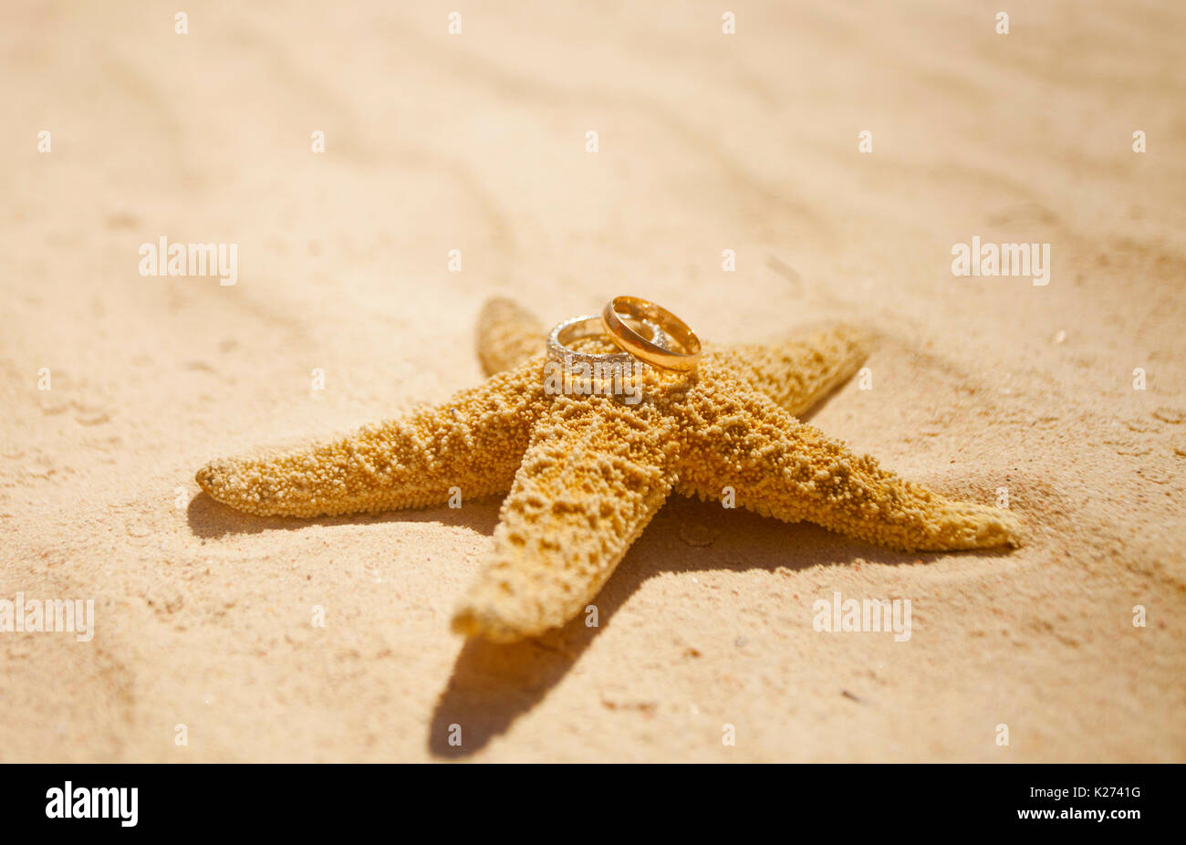 Wedding rings on a starfish on the beach. Sand in the sun Stock Photo ...