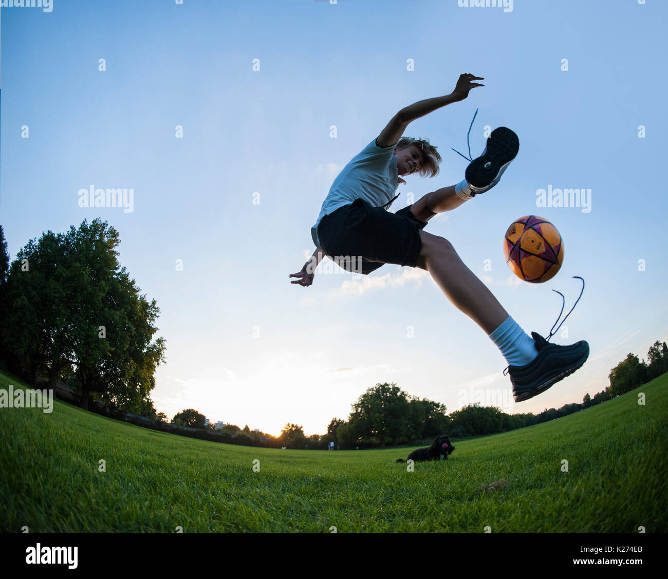 a young boy playing football and practicing his football skills and ...