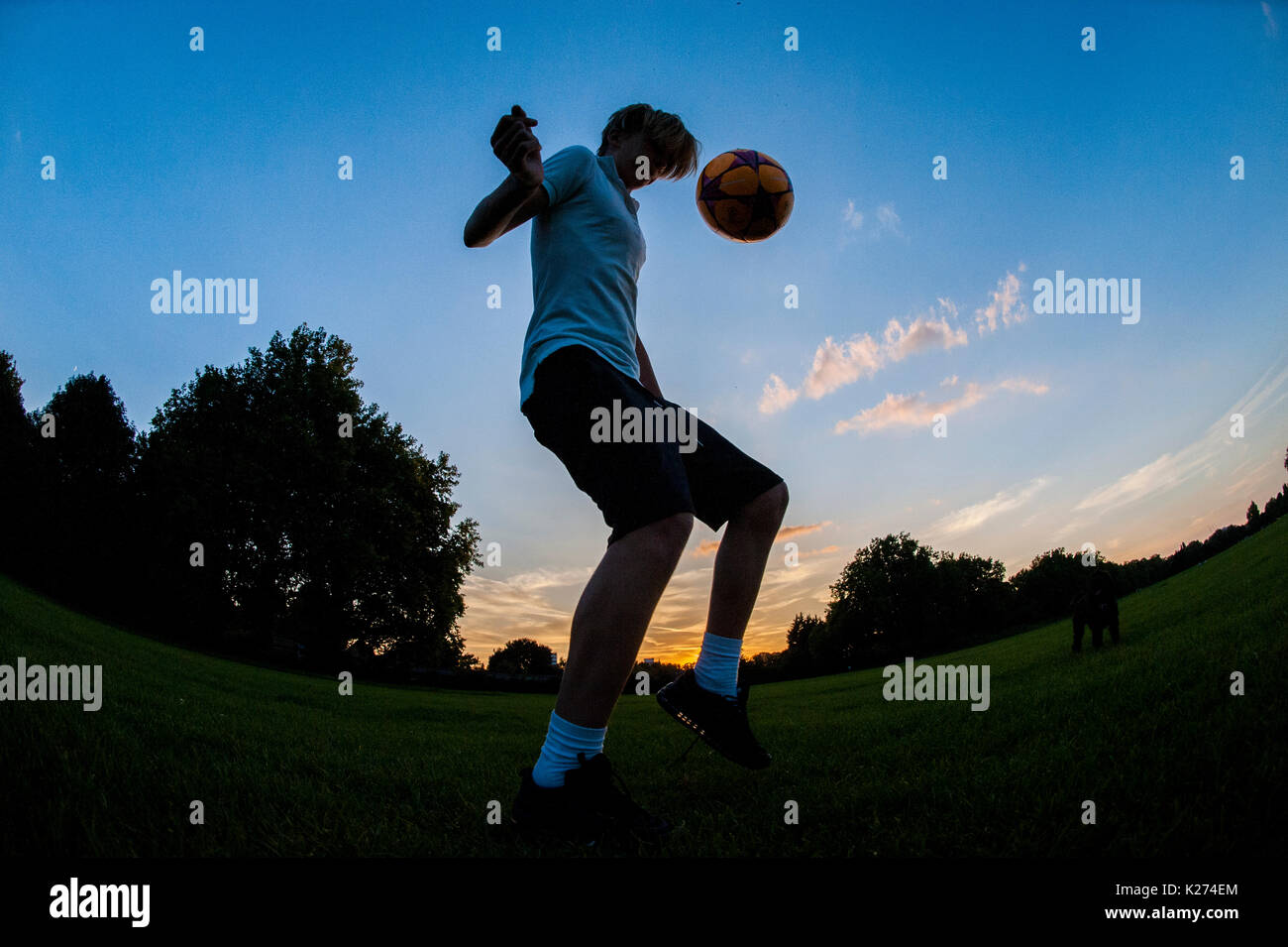 a young boy playing football and practicing his football skills and ...