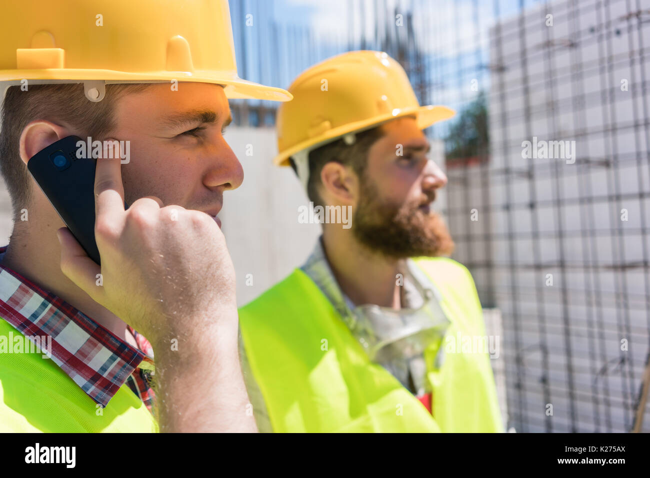 Worker talking on mobile phone during work on the construction s Stock ...