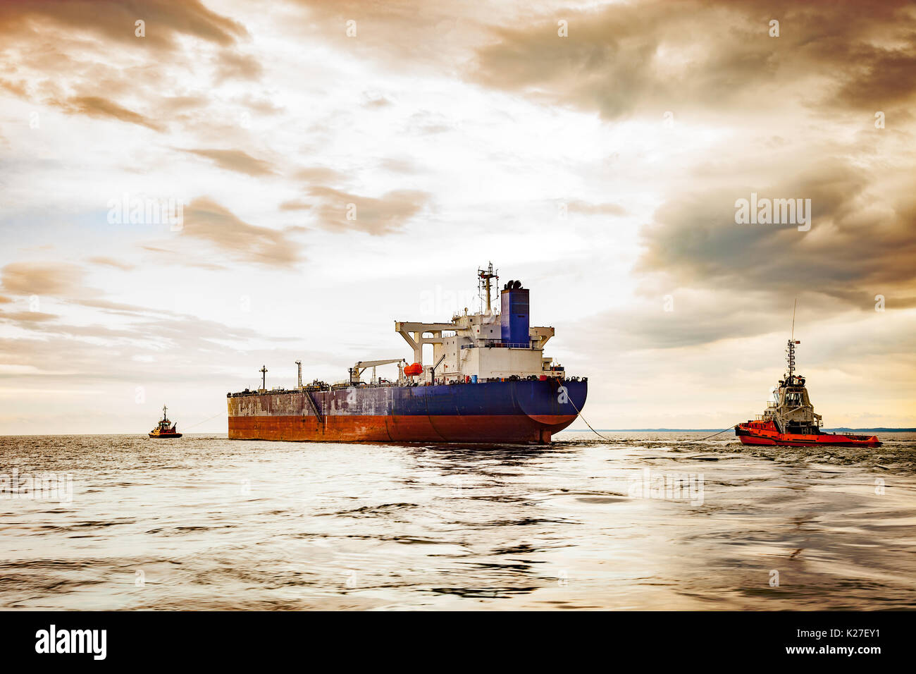 Tug boat towing a tanker ship at sea Stock Photo - Alamy