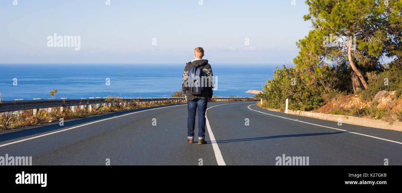people, travel and tourism - man with backpack walks on the road Stock ...