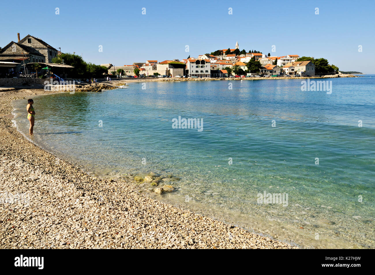 Woman standing on a shingle beach in Primosten, Croatia Stock Photo - Alamy