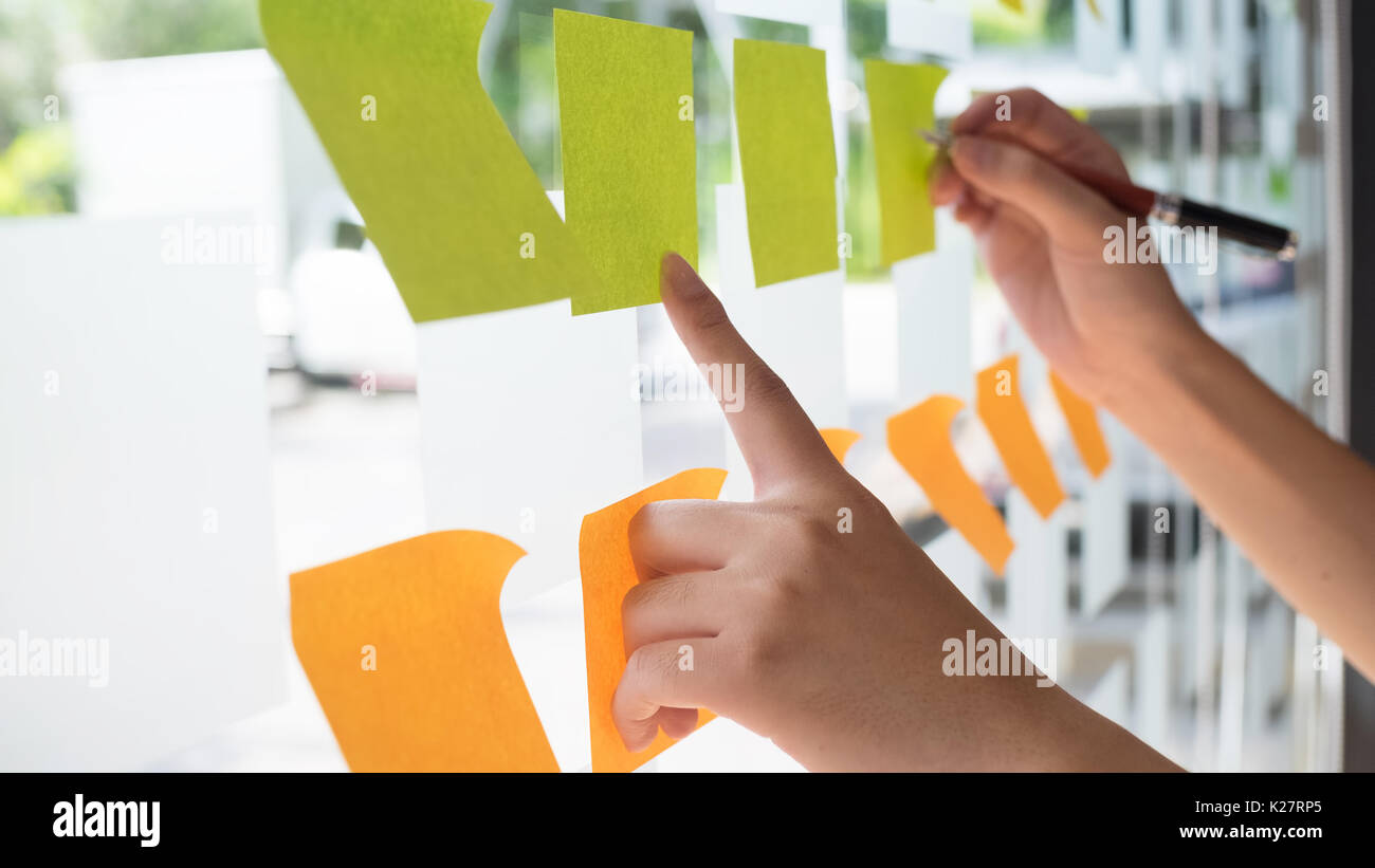 Hand using post it sticky note with brainstorming on note paper Stock ...