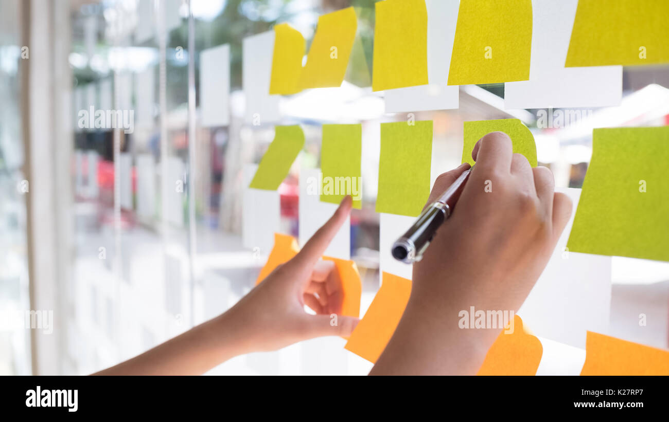 Hand using post it sticky note with brainstorming on note paper Stock ...