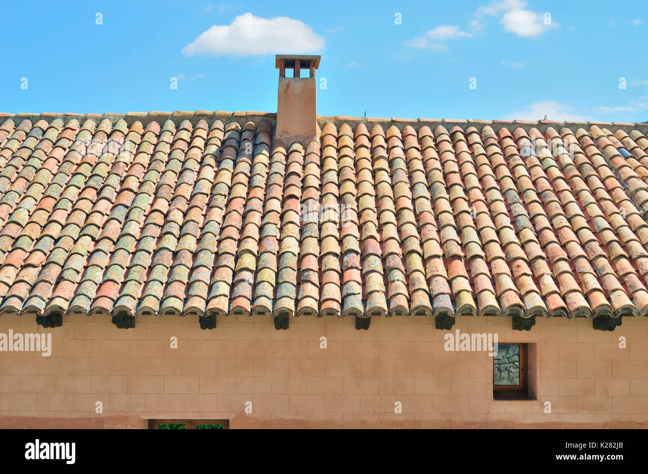 Beautiful classic roof. Rural tiles. Reddish color. Sunny day of summer ...