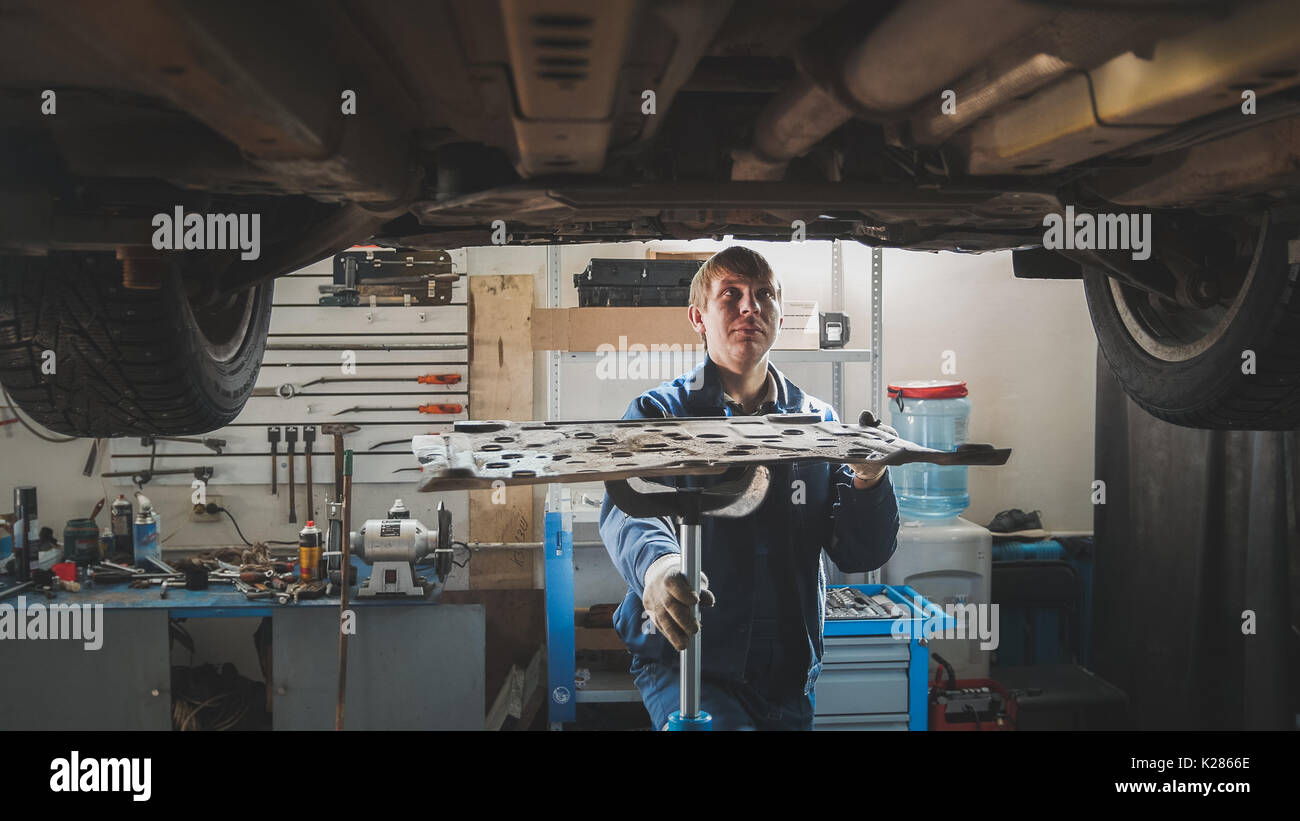Male caucasian worker - mechanic in automobile garage repairing ...