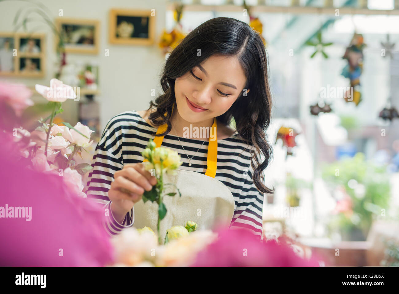 Pretty young florist with bouquet in flower shop Stock Photo - Alamy