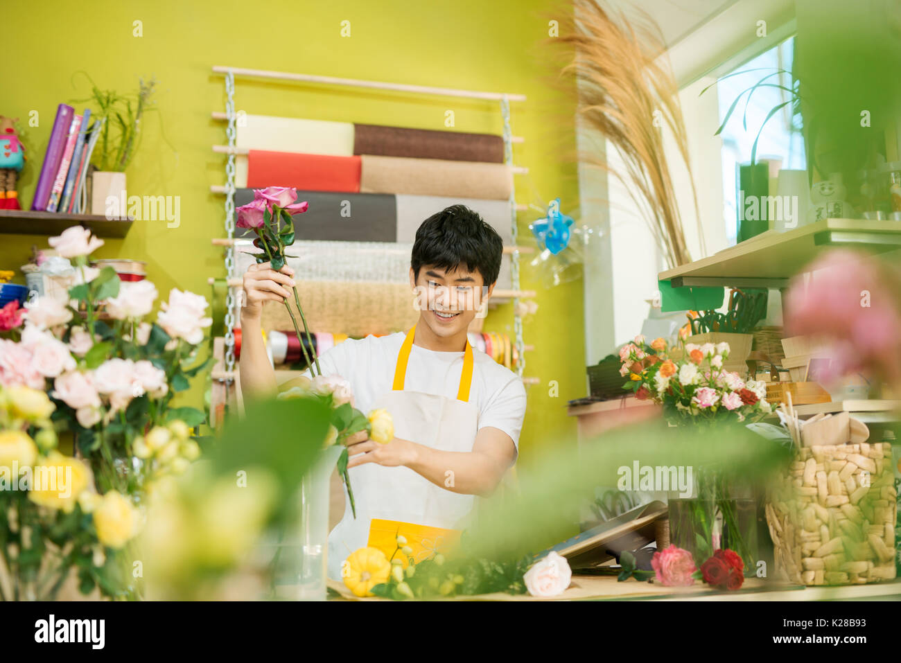 Smiling young asian florist man making bunch at flower shop Stock Photo ...
